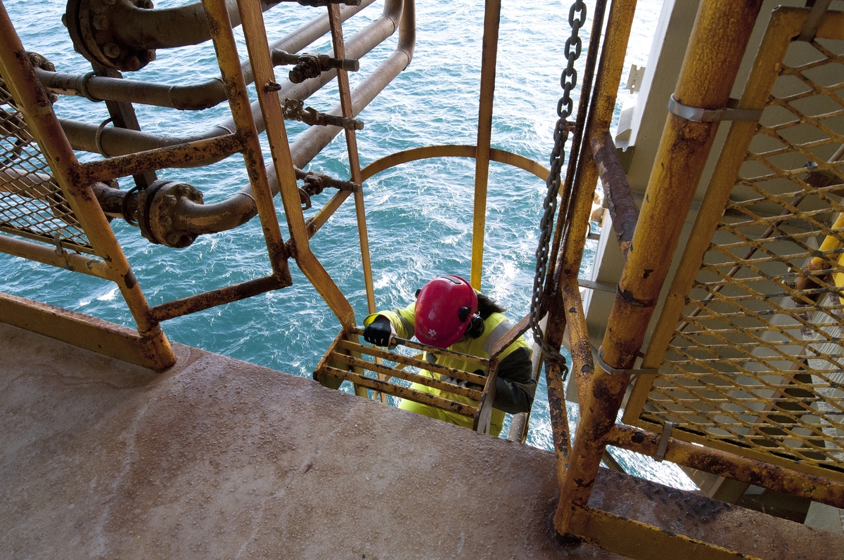 Norsk Oljemuseums fotograf Shadé Barka Martins på vei ned i stige som ...
