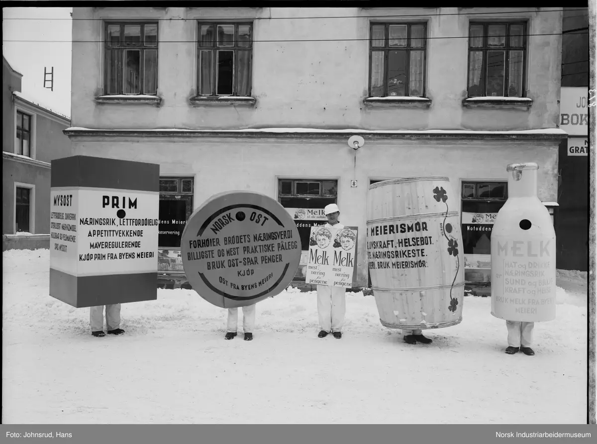 Reklame for Notodden Meieris produkter. Mennesker stående med skilt og ...