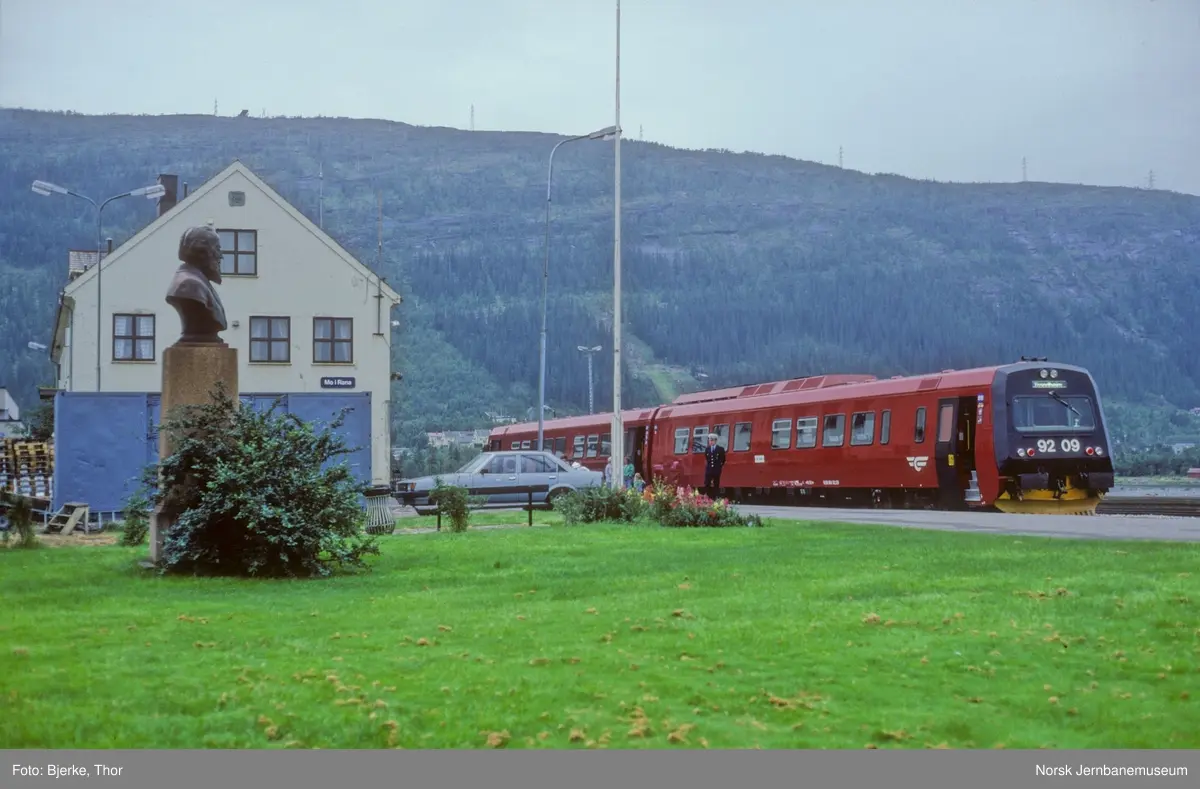 Mo i Rana stasjon med statuen over Ole Tobias Olsen og sørgående ...