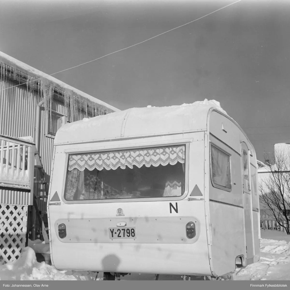 En campingvogn står parkert ute i snøen. Vognen har skiltnummer Y-2798 ...