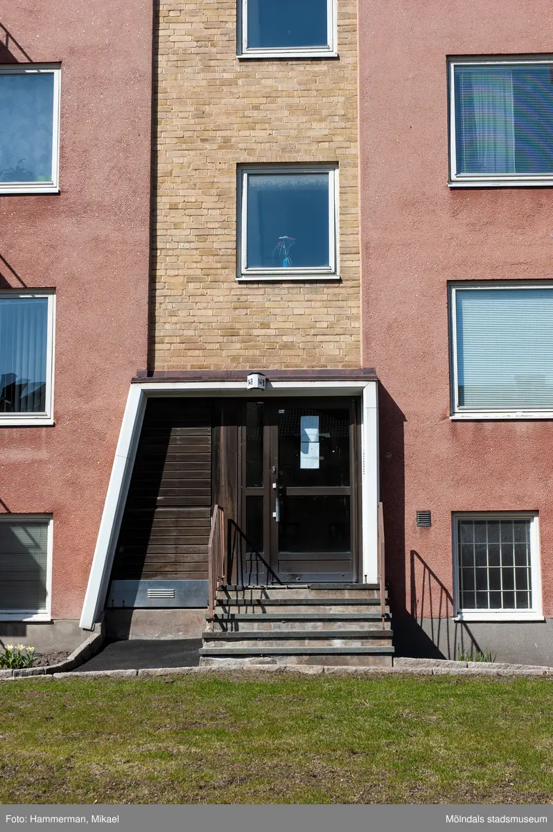 Fasad med port och fönster till bostadshuset Hagåkersgatan 14B i ...