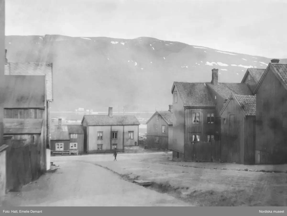 Stadsbild från Tromsø i Norge. Låga trähus kantar gatorna, i bakgrunden ...