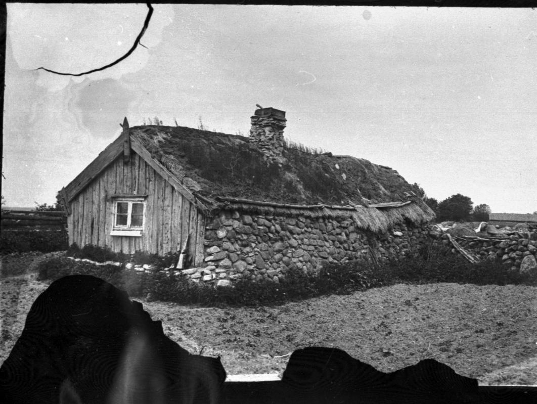 Gammal stuga, exteriör - stuga med torvtak och murad baksida av ...