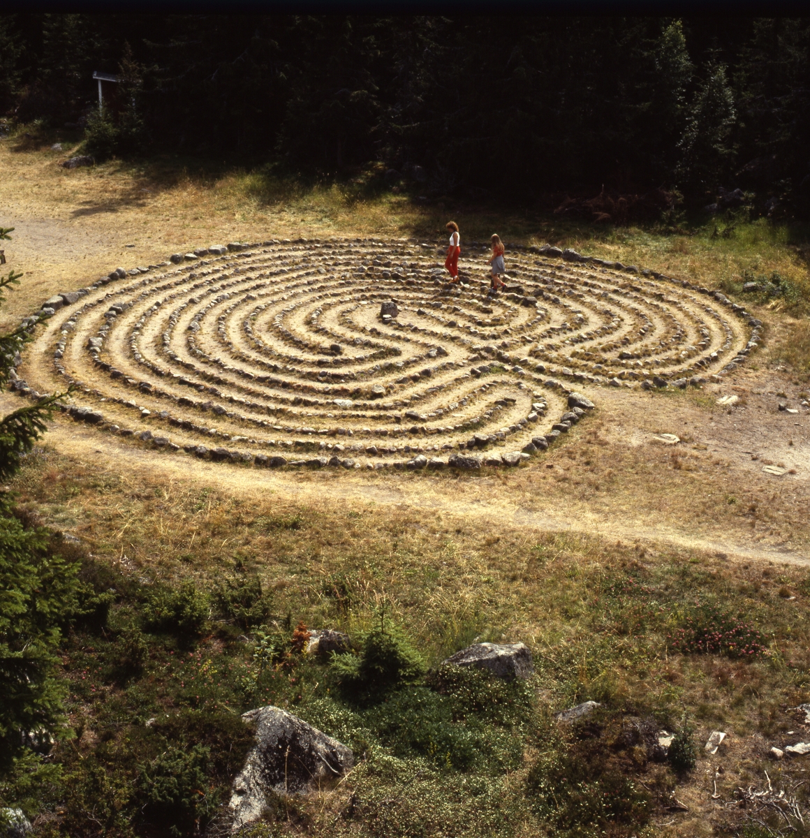 Två människor går runt i labyrinten vid Prästgrundet, Söderhamns-kusten ...