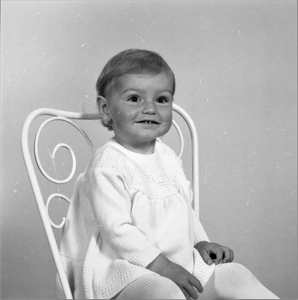 Portrett. Familie. Ung mørkblond pike med kort hår i lys heklet kjole ...