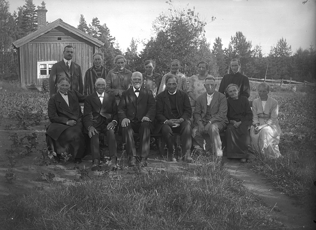 Grupp 14 personer. Bostadshus i bakgrunden. Sittande, från vänster: Ida ...