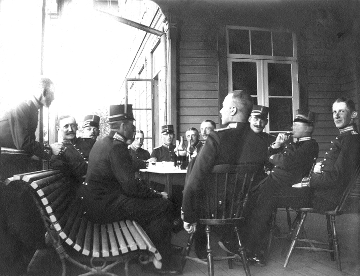 Ett antal officerare har samlats kring ett kaffebord med diverse ...