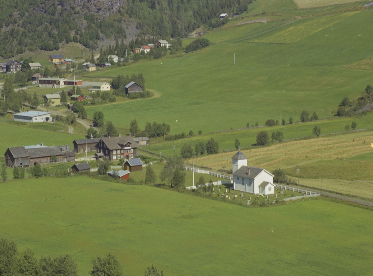 Olstad kapell, hvitmalt med kirkegård. Mo gård bak. Videre ...