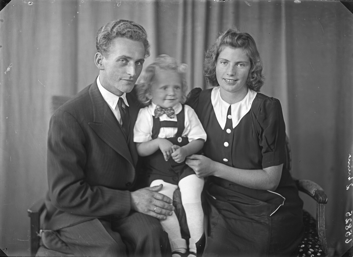 Gruppebilde. Familiegruppe på tre. Ung mann, ung gutt med langt lyst ...