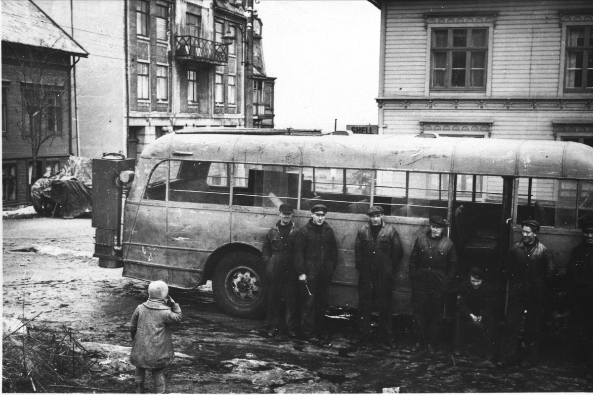 Menn foran buss med knottgenerator ved verkstedet til Harstad Bilsalg A ...
