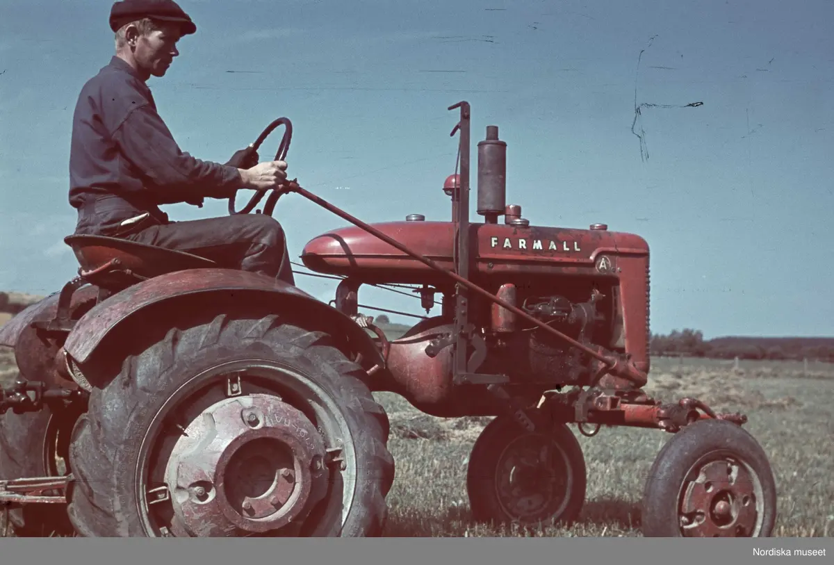 Man på en röd traktor av märket Farmall. - Nordiska museet / DigitaltMuseum